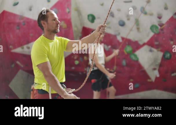 Man belaying another climber with rope. Top view of young athletic man ...