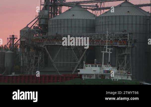 Panorama of big grain terminal at seaport in the evening. Cereals bulk ...