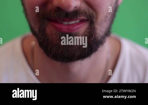 Young guy shows his teeth at the dentist with green screen background ...