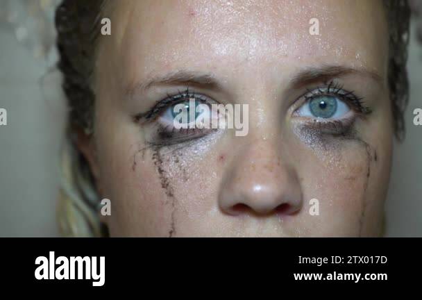 Smeared mascara on female eyes. A wet girl is looking into the frame ...