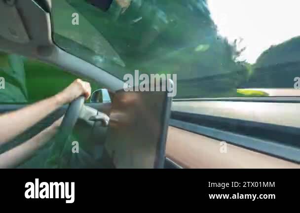 Person driving a new Tesla Model 3 in autopilot. The model 3 is set to ...