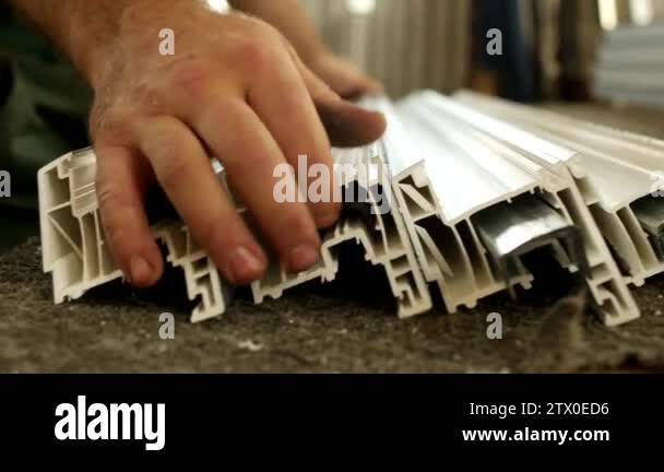 Manufacturing windows pvc, male worker inserts a metal profile into the ...