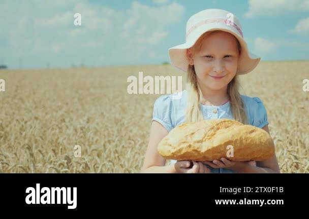 Portrait of a girl with a loaf of bread. Standing on the wheat field ...
