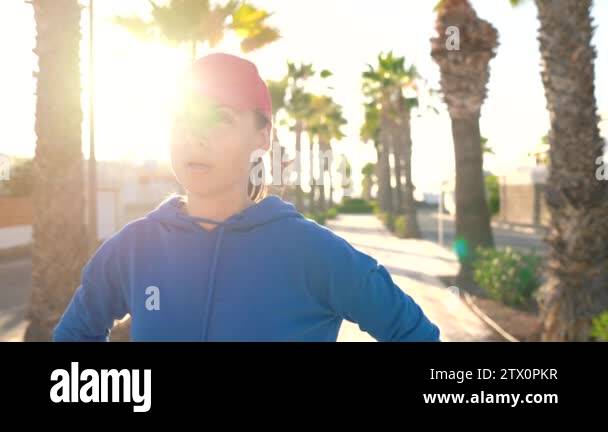 Woman stops while jogging to check the data in the smart watch ...