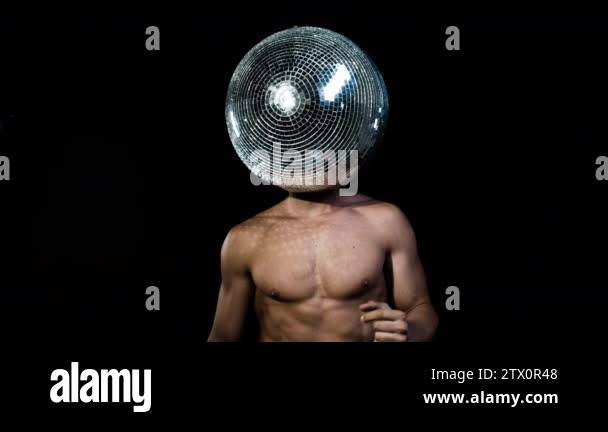 Muscular man dancing with mirror ball on head on black background Stock ...