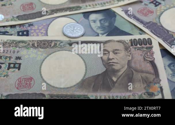 Close up of Japanese coin yen falling on banknotes 1000 and 10000 yen ...