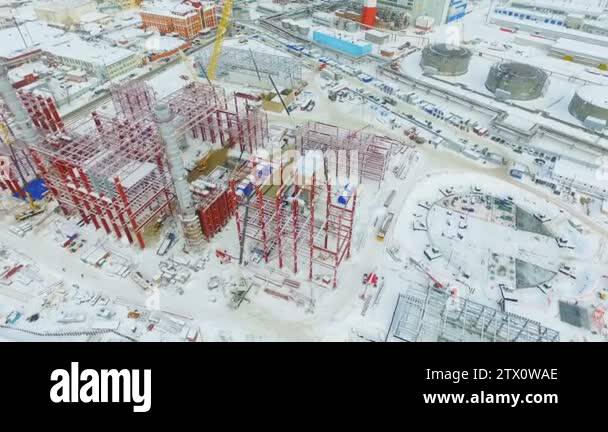 Snow-covered thermal power plant territory with buildings under ...