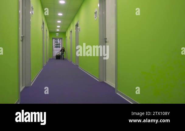 Little girl with baggage running in corridor in hotel and showing ...