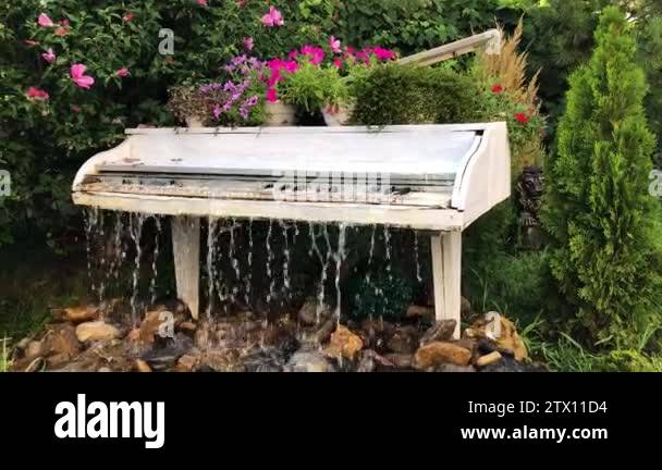 White grand piano water fountain in the summer garden Stock Video ...