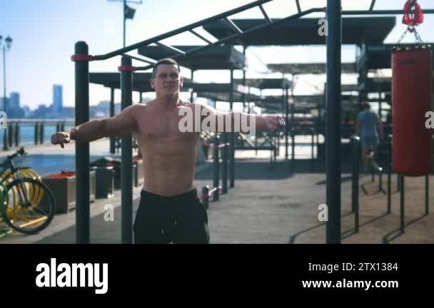 Man bodybuilder doing exercises for warm-up outdoor before training ...