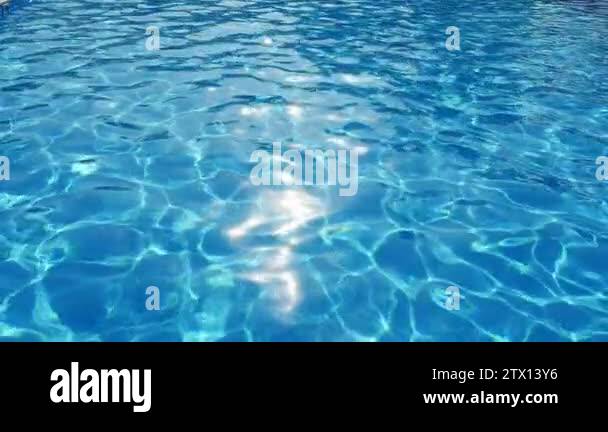 Splendid swimming pool water glittering with its swaying blue waves in ...