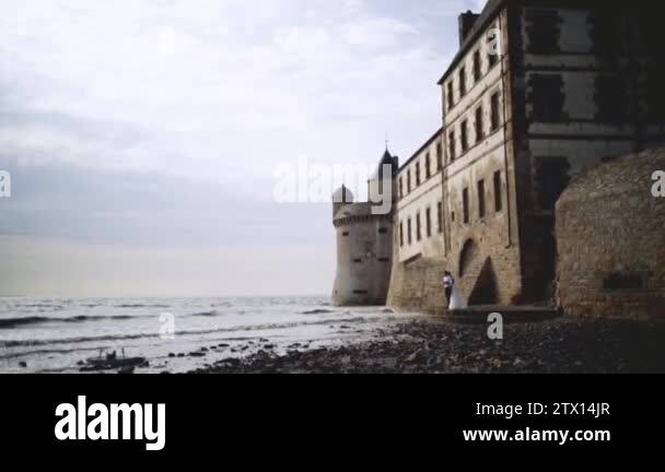 Couple of medieval coastal fortress. Action. Beautiful newlyweds stand ...