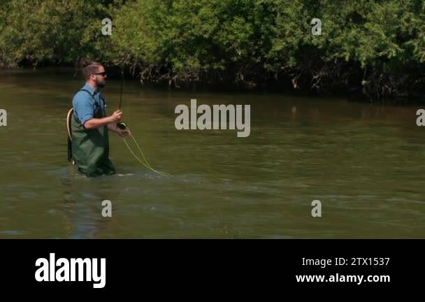 fisherman throws a float, a man fishing on the river, standing in the ...