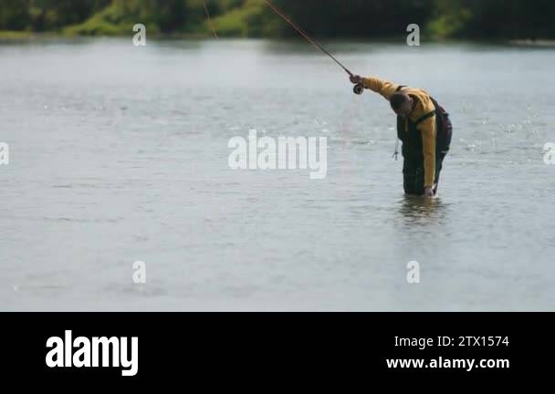 man fisherman throws a float, caught a fish by hand in the river Stock ...