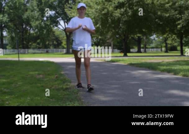 Woman throwing a plastic bottle on the grass in the park and leaving ...