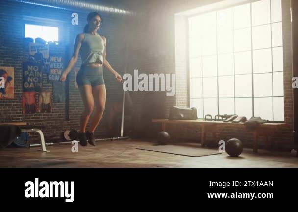 Strong Athletic Woman Exercises with Jumping Rope in a Loft Style ...