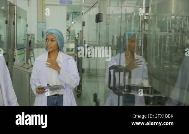 Two engineers in white uniform control production process in a factory ...