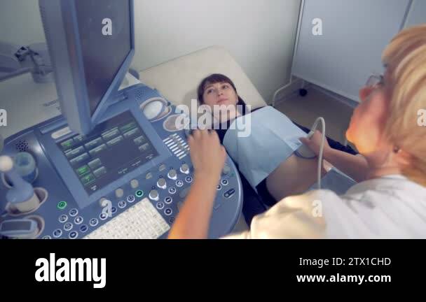 Female gynecologist is carrying out an ultrasound procedure on a ...