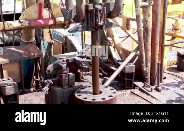 The lifting mechanism of the rig slowly lifts the metal pipe out of the ...