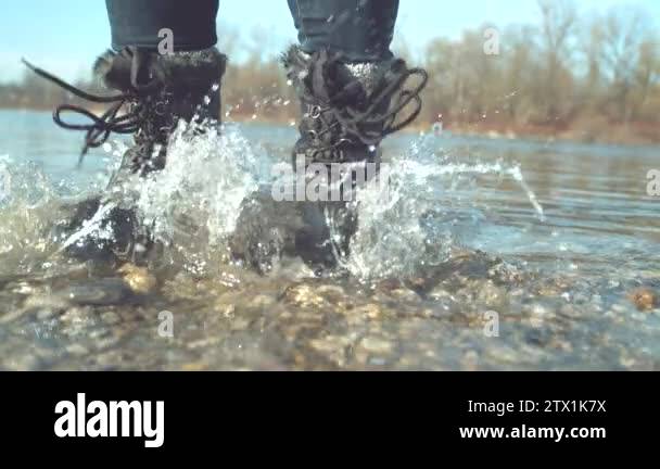 SLOW MOTION, CLOSE UP Cheerful girl stomping her feet in the shallow ...