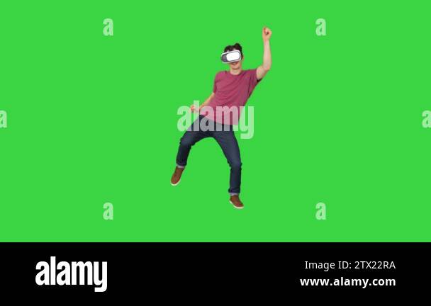 Advanced gamer in casual outfit playing dancing game in VG headset on a ...