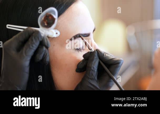 close up. young woman gets eyebrow correction procedure. kosmetolog ...