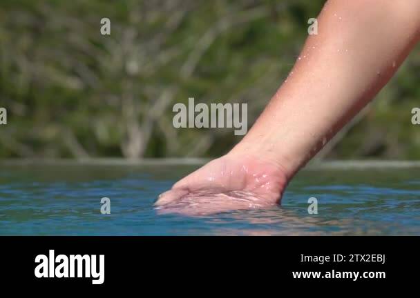 SLOW MOTION CLOSE UP: Caucasian female hand playing with water ...