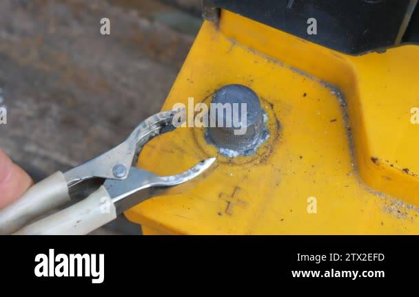 The male hand detach the terminals to the cars batteries for charging ...