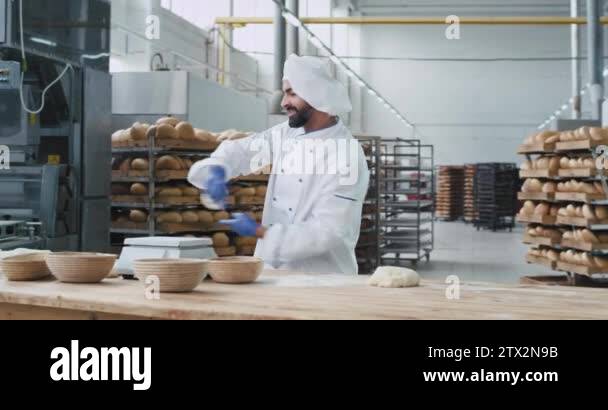 Charismatic baker with beard in a big bakery industry dancing while ...