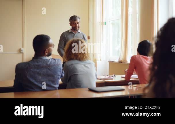 Curious student is raising hand and asking question, her experienced ...