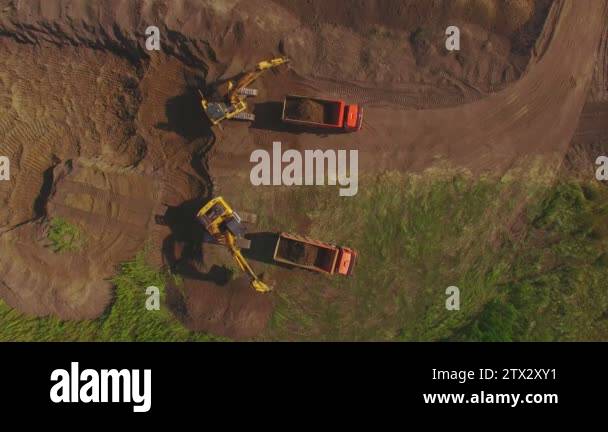 Two excavators scoop loads a dump truck. Construction site. Aerial view ...