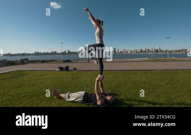 Young sporty couple practicing acrobatics performing front plank bird ...