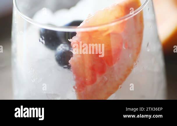 Adding fresh fruit to glass of crushed ice and pouring carbonated water over Stock Video Footage ...