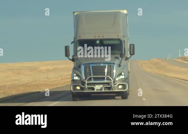 CLOSE UP: Unrecognizable grey semi truck driving directly into camera ...