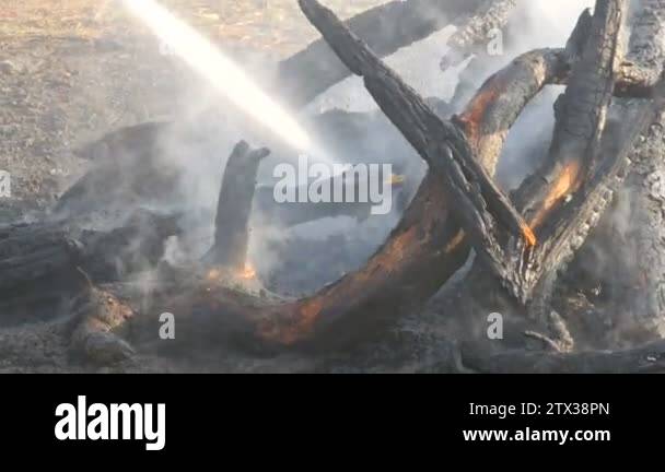 Fireman extinguishes a fire from a fire hose. Burned to the coals ...