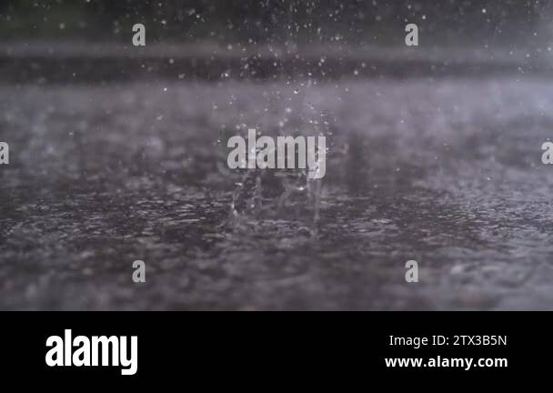 SLOW MOTION CLOSE UP: Autumn rain water drops falling into big puddle ...