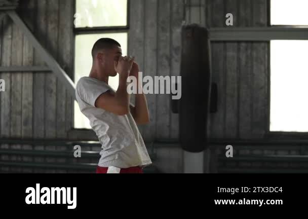 Side view of a male boxer warming up. Twisting his body,hips, holding ...