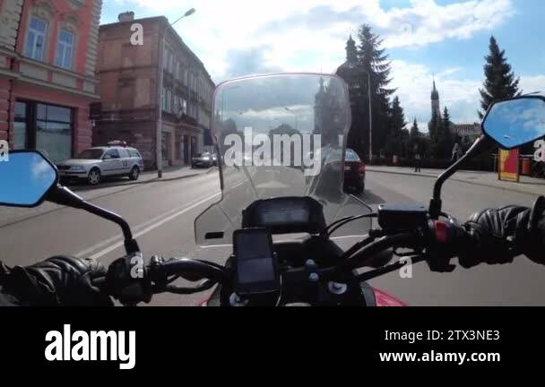 Moto biker driving a motorcycle rides in the city. View from behind the ...