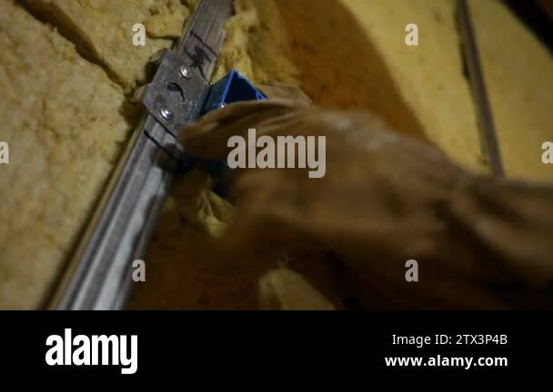 Home Owner inspecting electrical lines in a box in unfinished basement ...