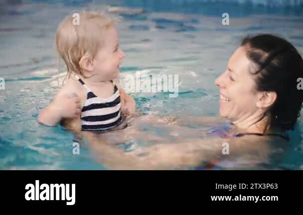 Swimming pool. Mom teaches a young child to swim in the pool Stock ...