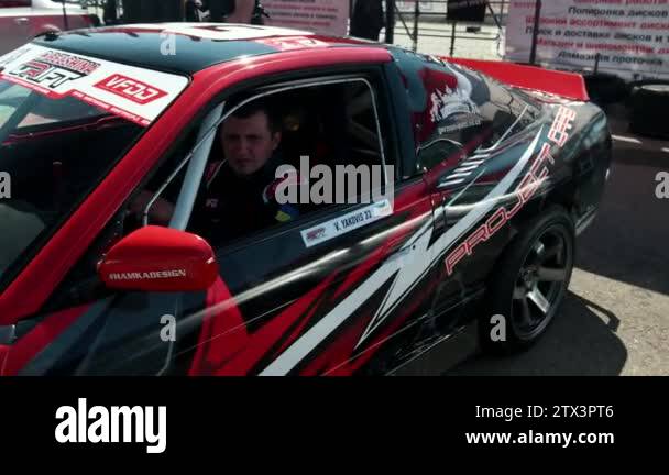 young man, driver sitting behind the wheel of a red sports car for ...