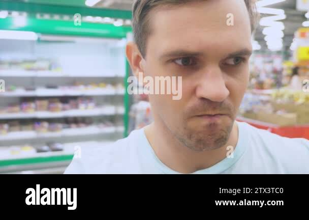 In the supermarket, a close-up of the face of the husband who expects ...