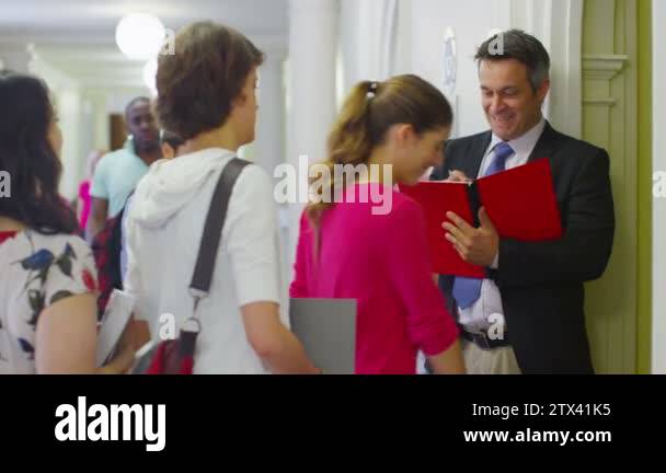 Teacher checking register as students enter classroom Stock Video ...