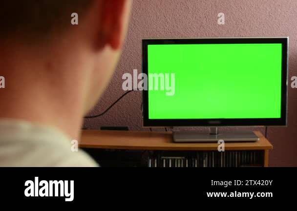 Man watches TV(television) - green screen - discontented man shakes his ...