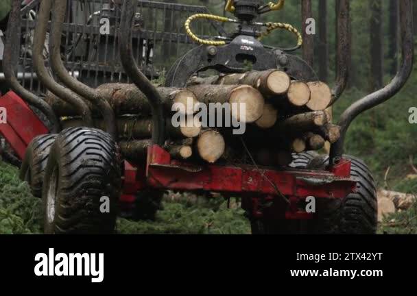CLOSE UP, DOF: Timberjack harvester with swing arm and claw towing half ...