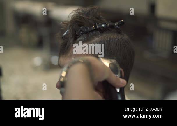 Cutting male hair with electric razor in barbershop. Close up haircut ...