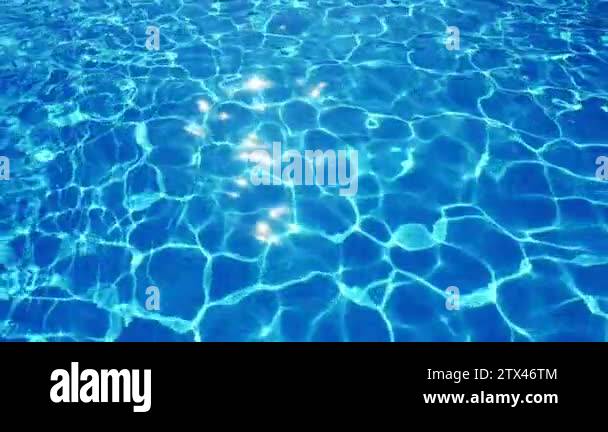 Dazzling swimming pool waters shining with its playing cyan waves in ...