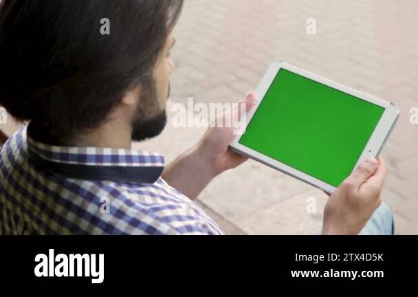 Man is sitting and holding pad in hands. Then he starts to slide on ...