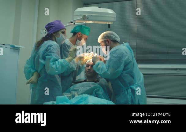 Baldness treatment. Hair transplant. Surgeons in the operating room ...