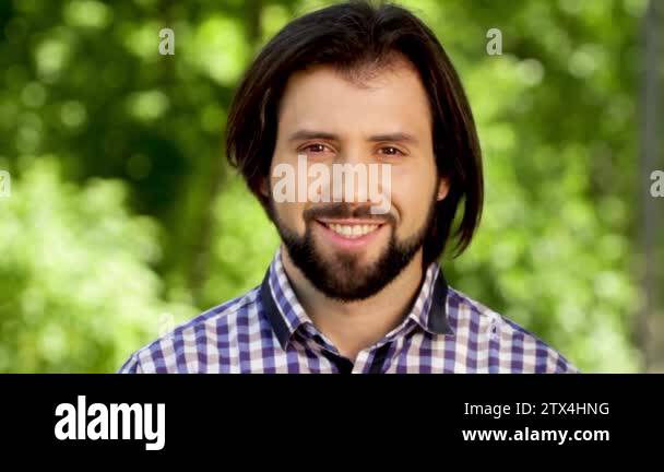 Brunette man is looking on camera with serious sight. Then he starts to ...
